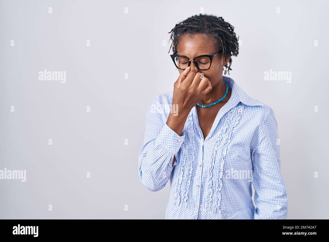 African woman with dreadlocks standing over white background wearing ...