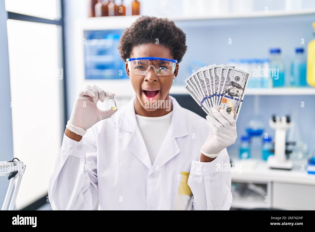 African american woman working at scientist laboratory holding dollars ...