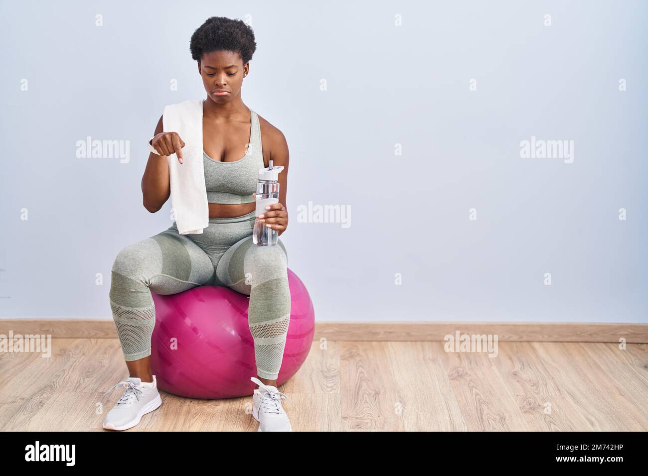 African american woman wearing sportswear sitting on pilates ball ...