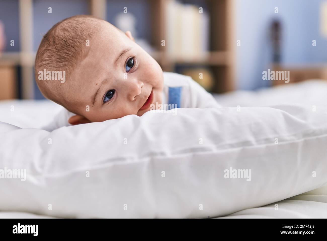 Adorable baby relaxed lying on bed at bedroom Stock Photo - Alamy