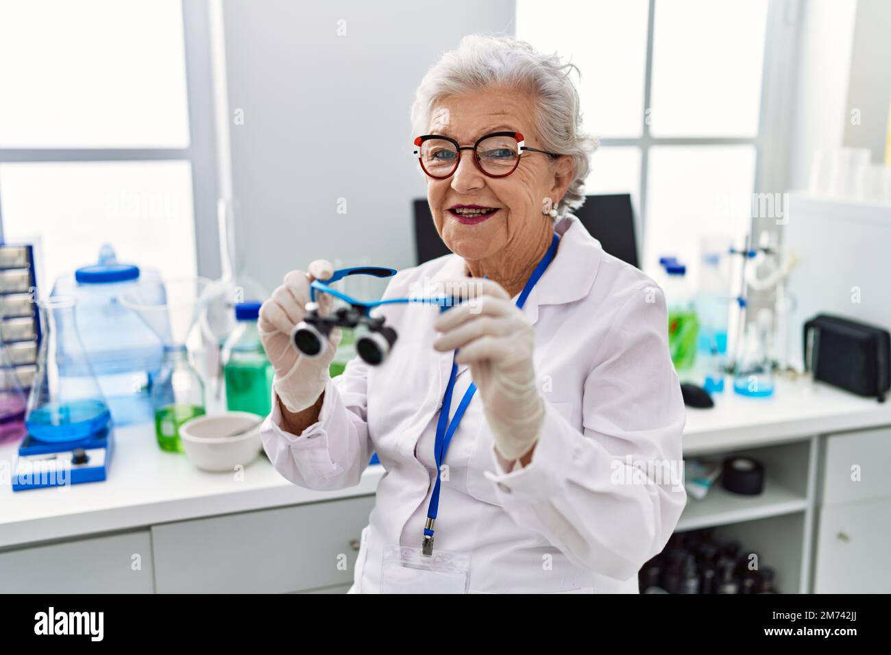 Senior woman with grey hair working at scientist laboratory using ...