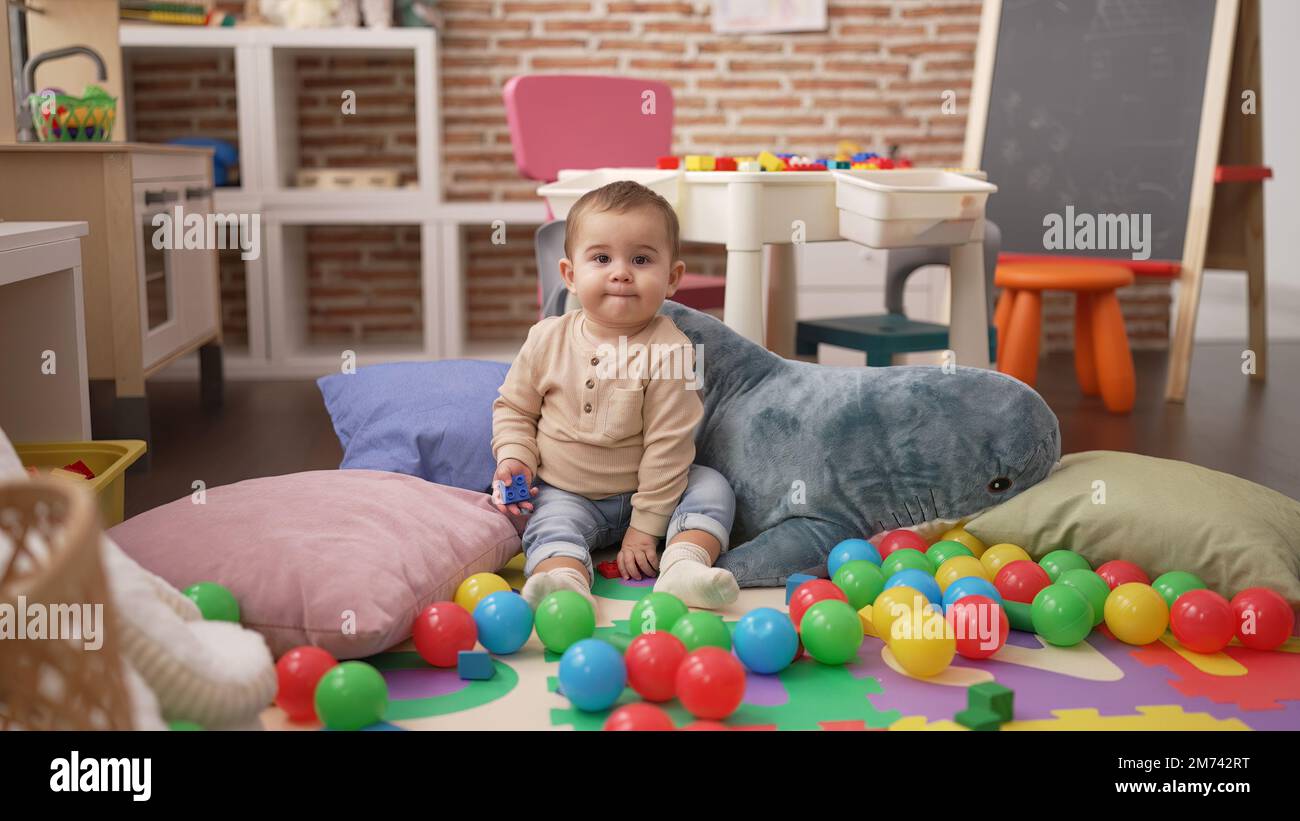 Adorable toddler playing with wooden construction blocks sitting on ...