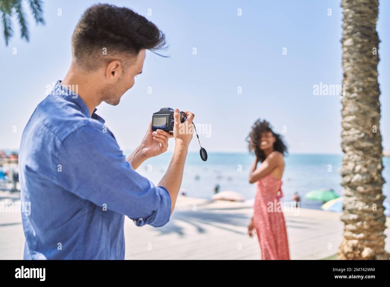 Man and woman couple make photo using camera at seaside Stock Photo - Alamy
