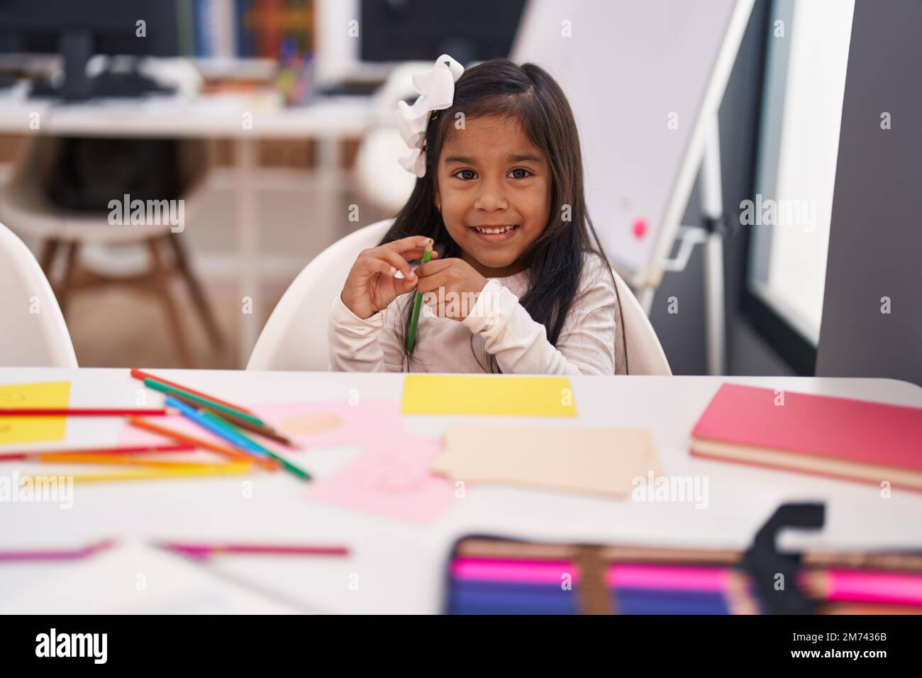 Adorable hispanic girl student smiling confident holding color pencil ...