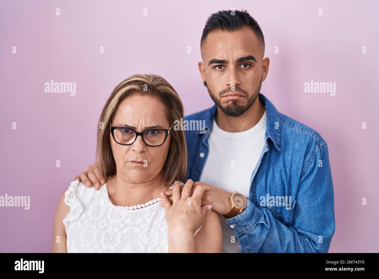 Hispanic mother and son standing together depressed and worry for ...