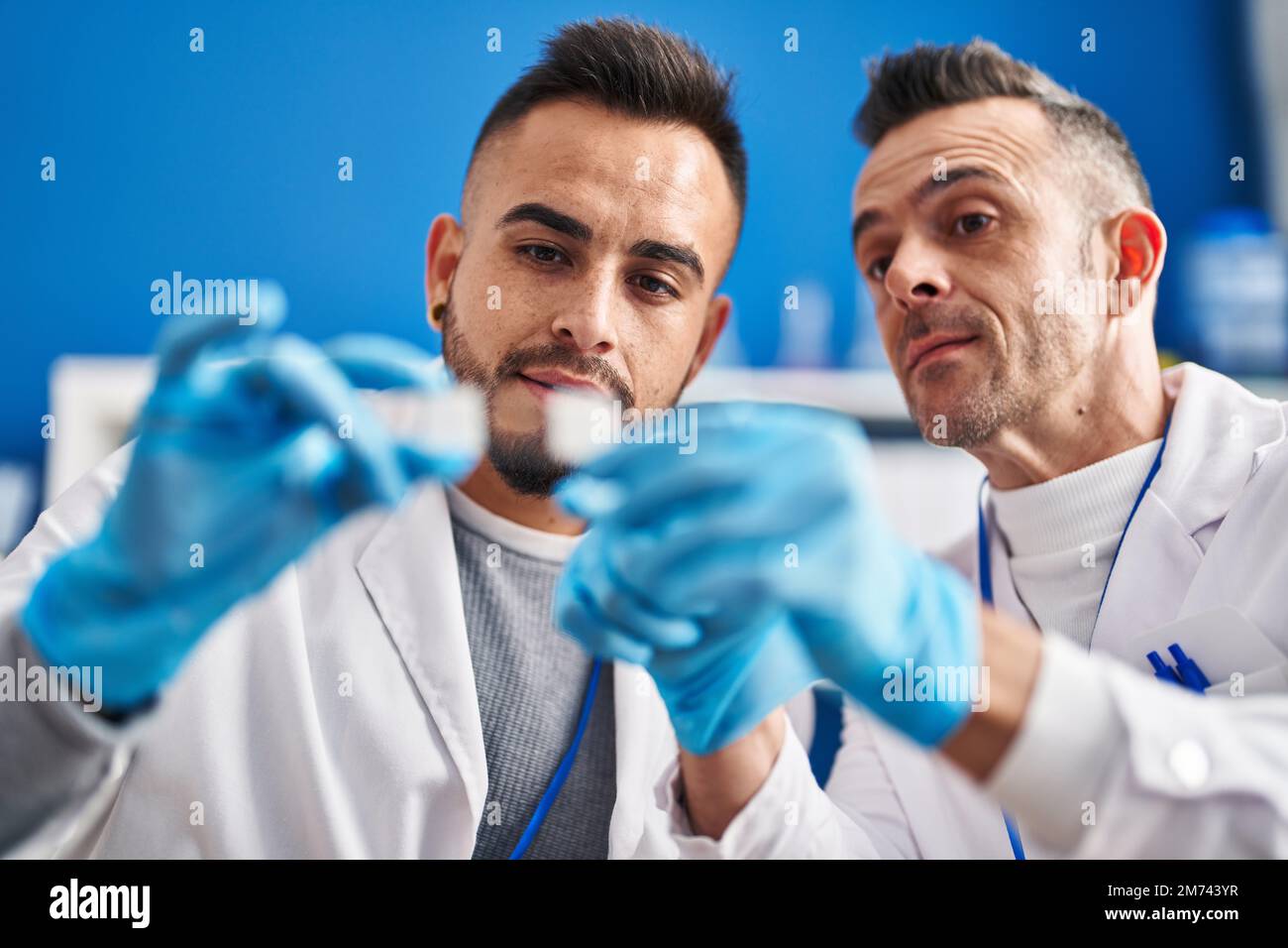 Two men scientists looking sample at street Stock Photo - Alamy