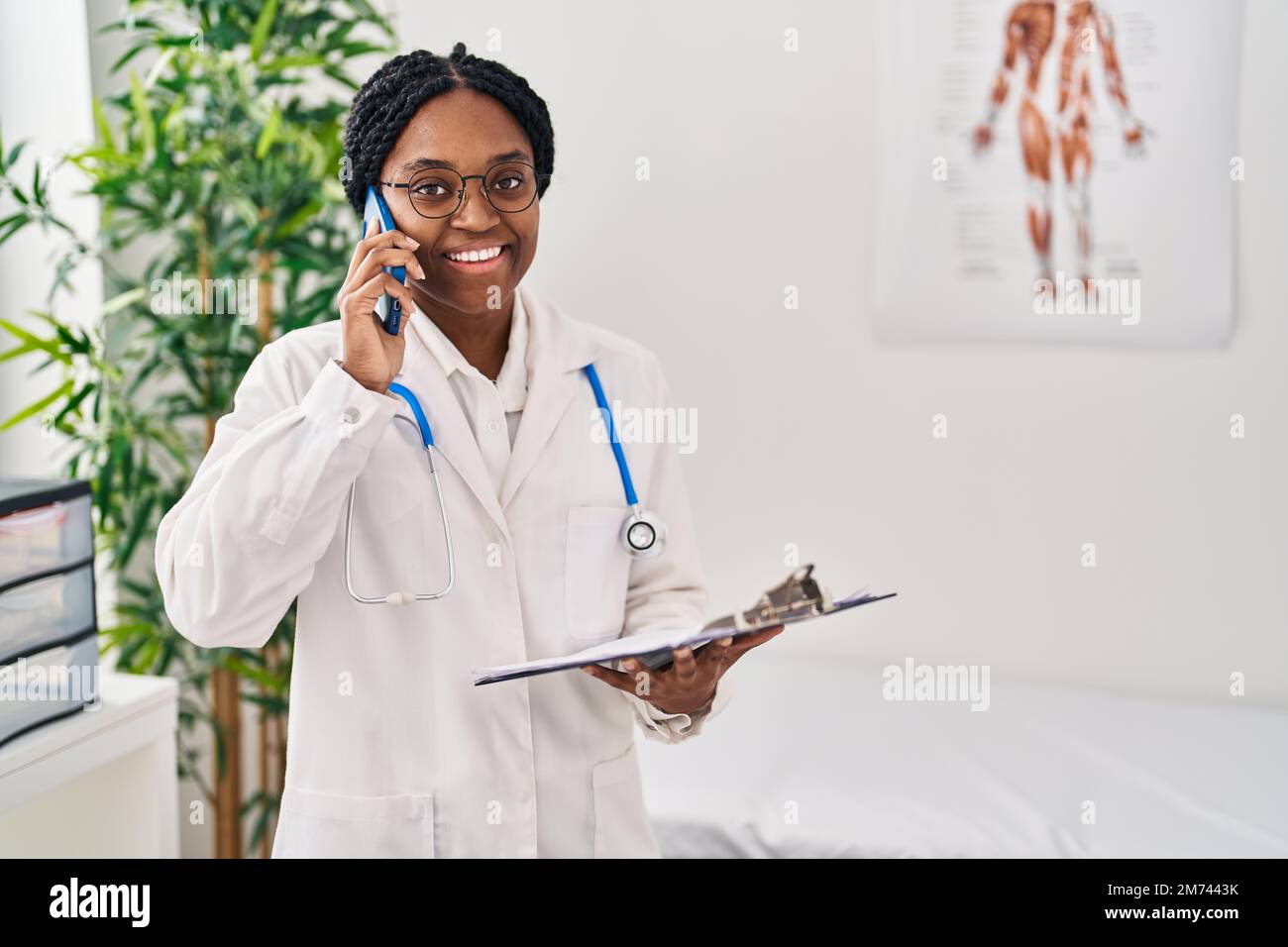 African american woman doctor talking on smartphone reading document at ...