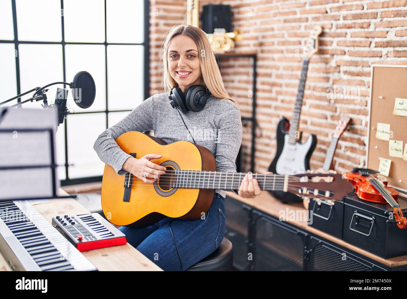 Young woman artist singing song playing classical guitar at music ...