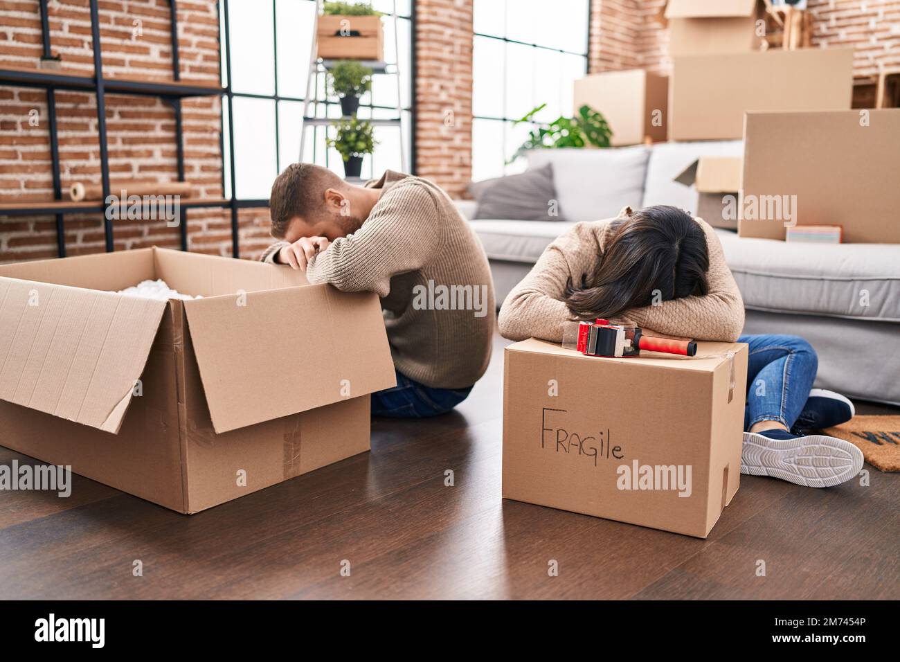 Man and woman couple packing fragile cardboard box at new home Stock ...