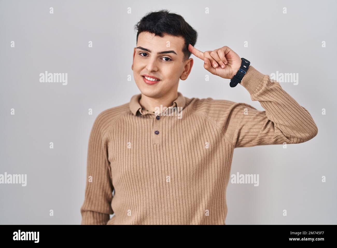 Non binary person standing over isolated background smiling pointing to ...