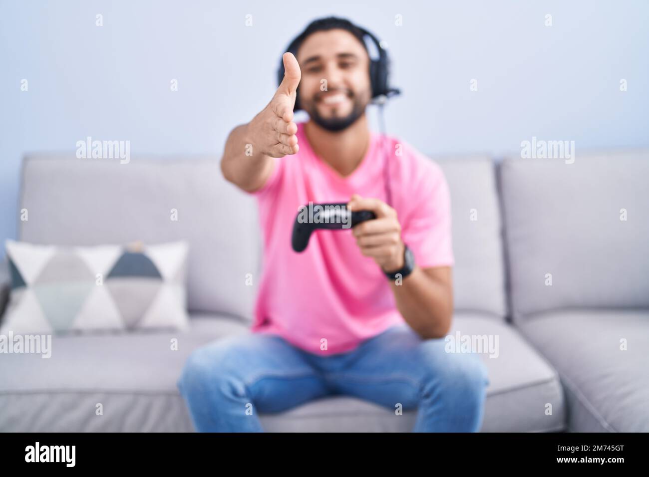 Hispanic young man playing video game holding controller sitting on the ...