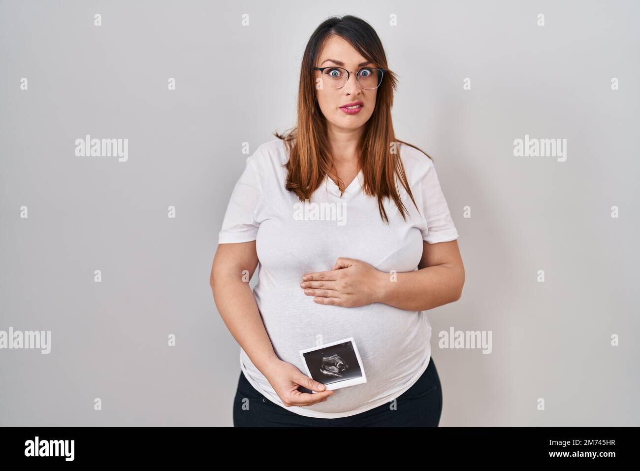 Pregnant woman holding baby ecography clueless and confused expression ...