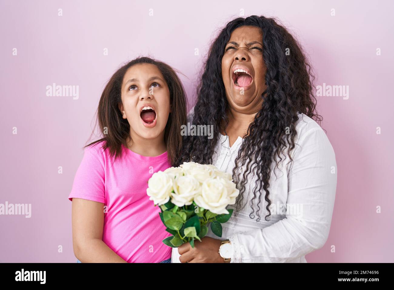 Mother and young daughter holding bouquet of white flowers angry and ...