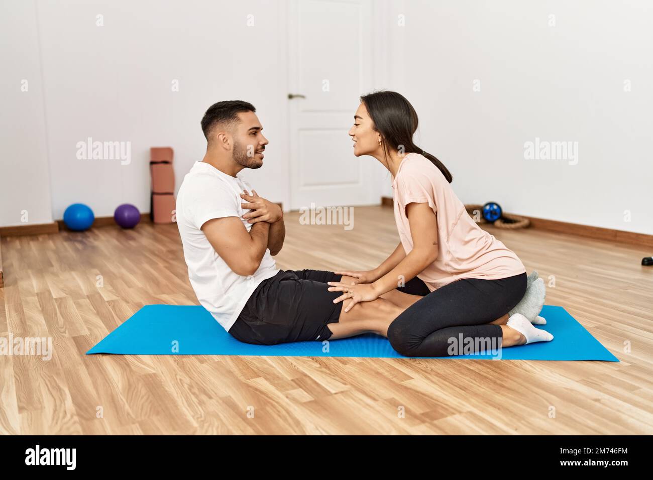 Latin man and woman couple smiling confident training abs exercise at ...