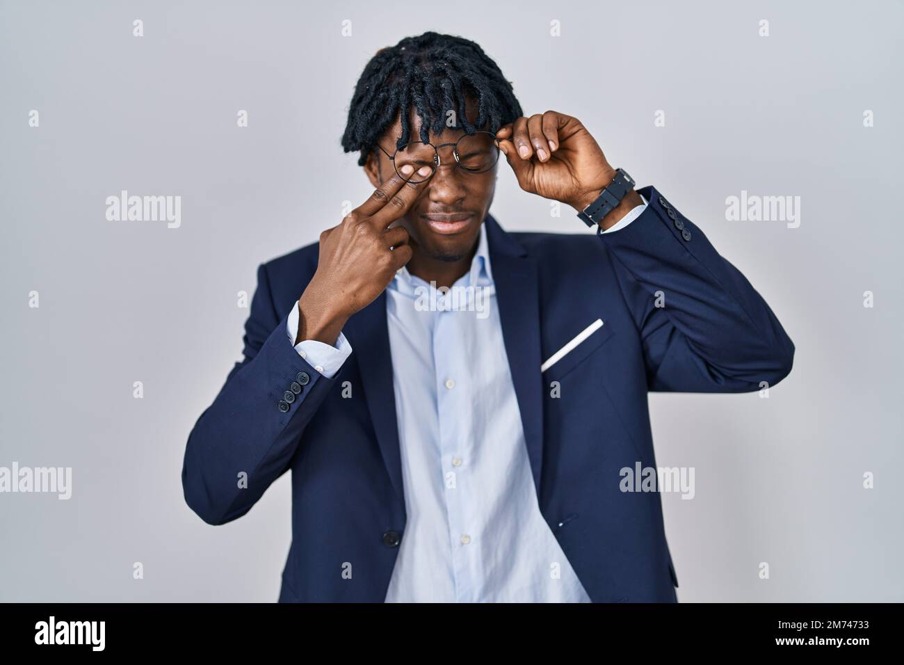 Young african man with dreadlocks wearing business jacket over white ...