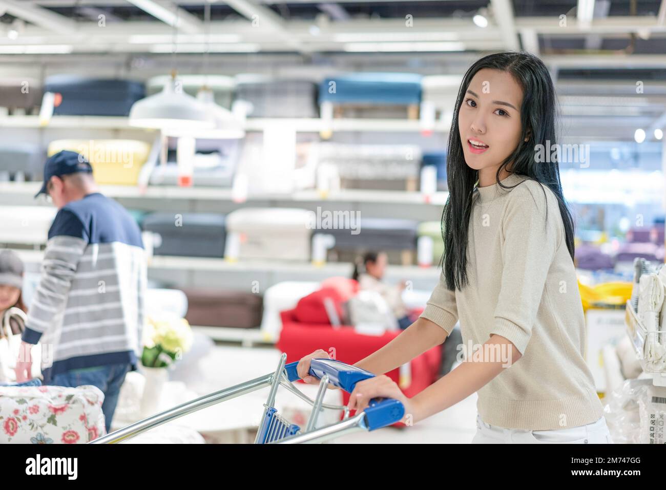 The young woman push a shopping cart Stock Photo - Alamy