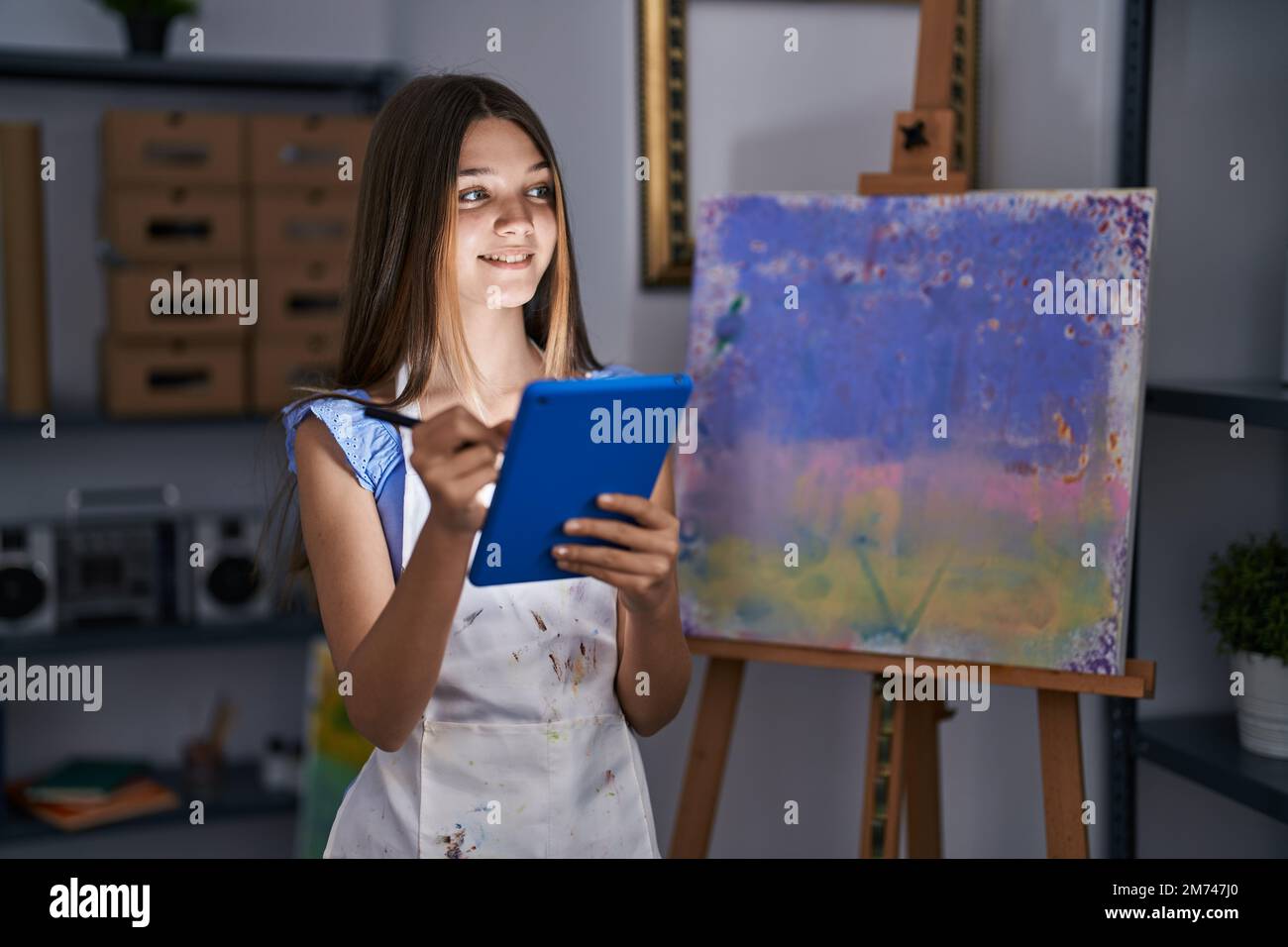 Adorable girl artist using touchpad drawing at art studio Stock Photo ...