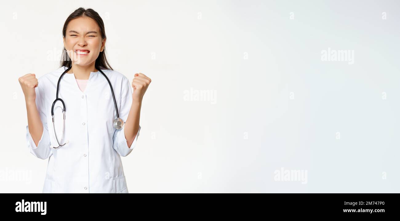 Happy asian intern celebrating. Physician doctor triumphing and ...