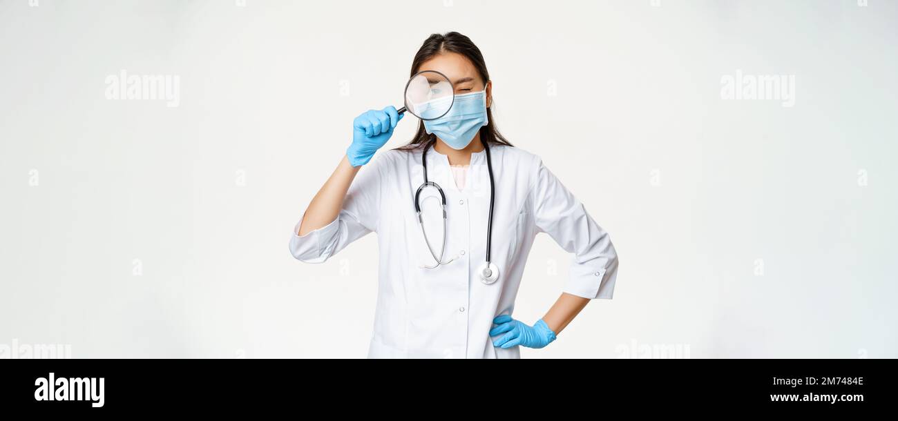Asian female doctor looking through magnifying glass, examine patient ...