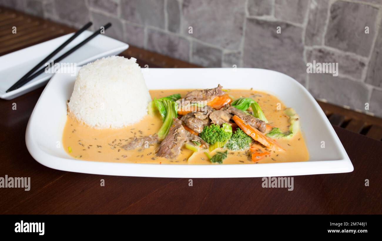 Asian combo plate with beef in curry sauce and vegetables served with ...