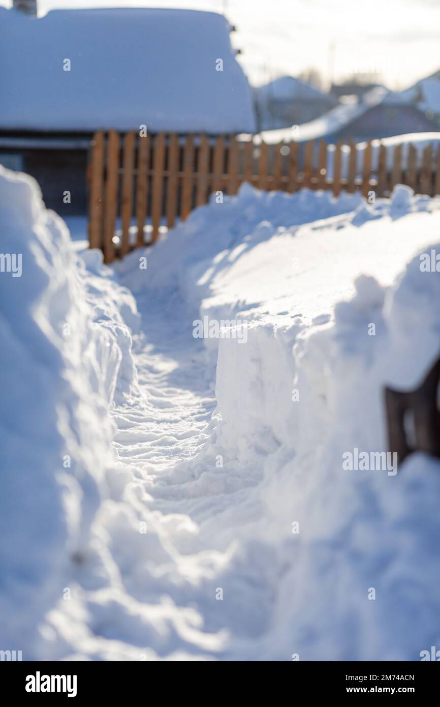 A man dug a passage through a lot of snow. Clearing snow to the house ...