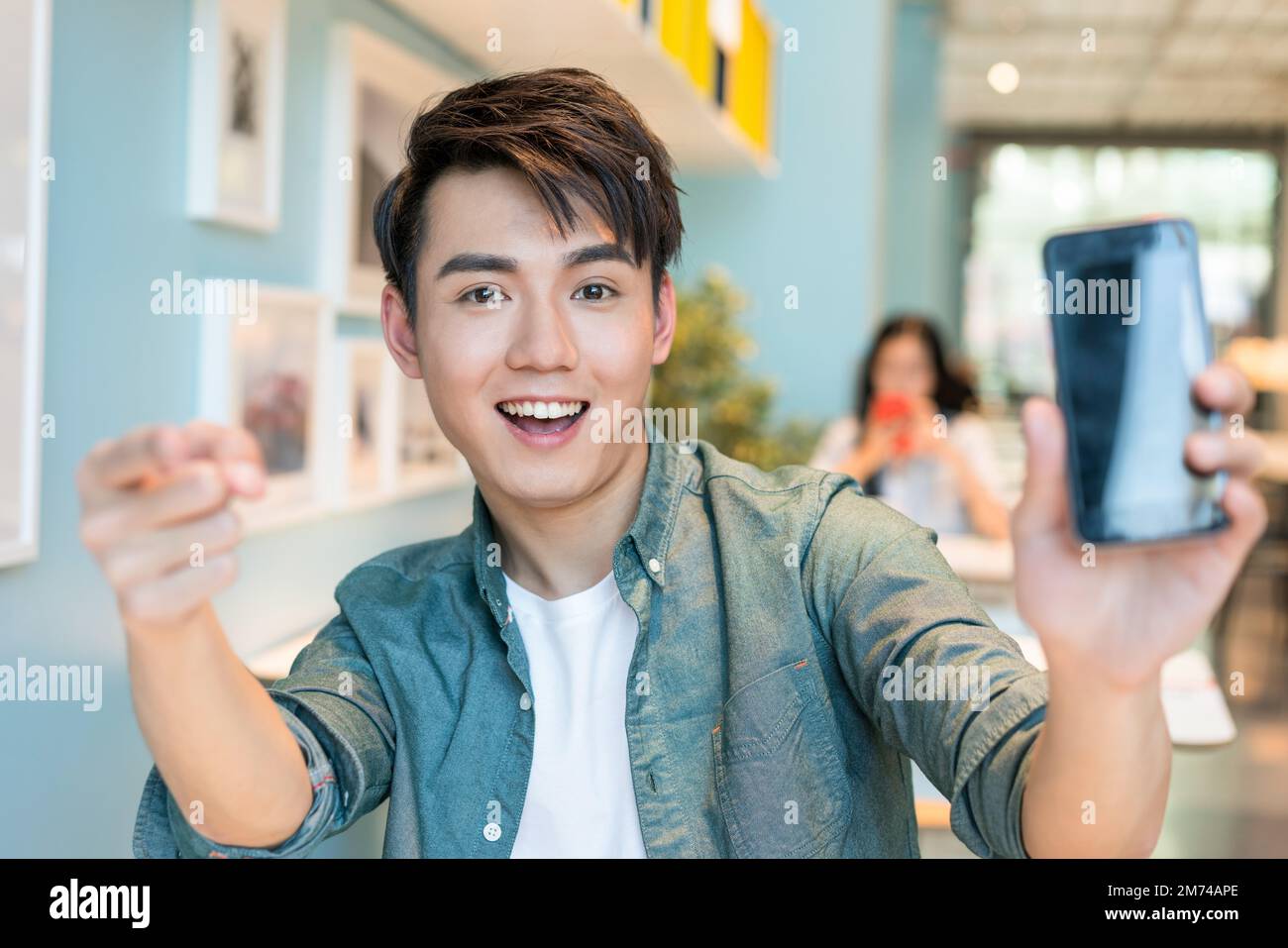 Young men show a mobile phone Stock Photo - Alamy