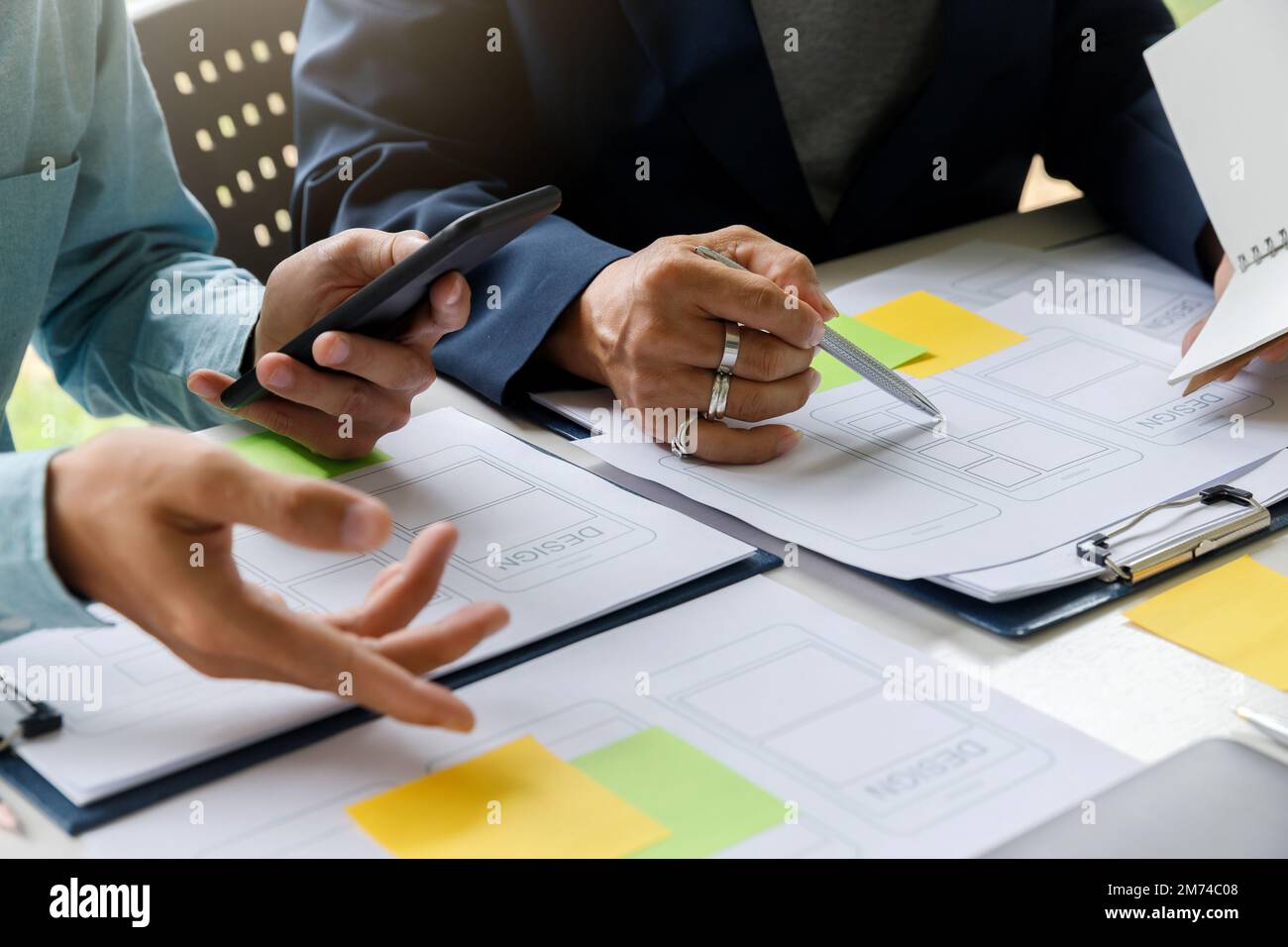 UX or UI designers designing on their smartphone application layout ...