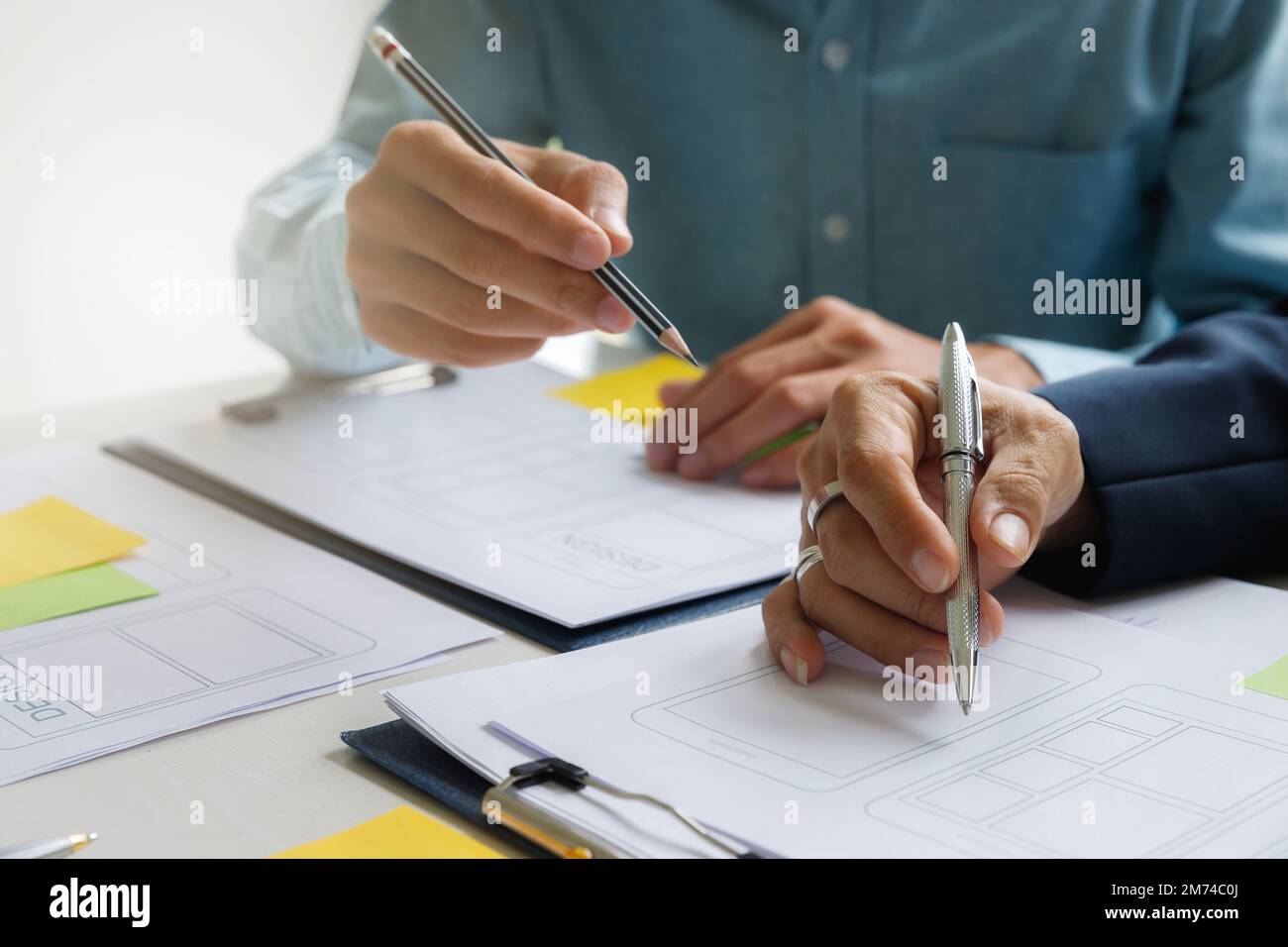 UX or UI designers designing on their smartphone application layout ...