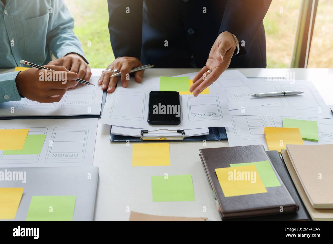 UX or UI designers designing on their smartphone application layout ...