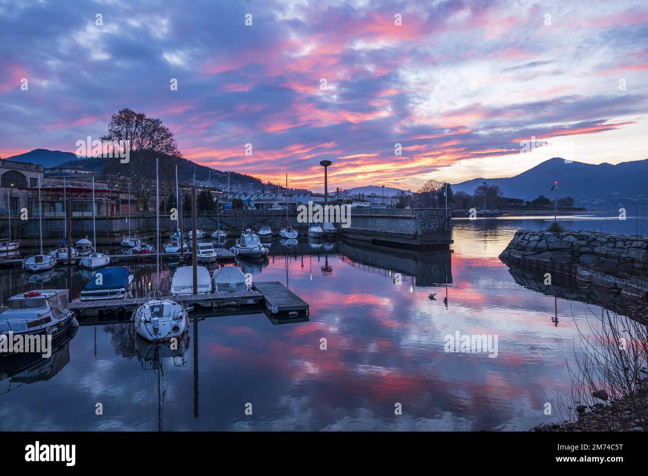 Beautiful sunset with colored clouds and boats that are reflected in ...