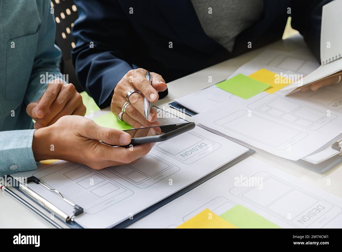UX or UI designers designing on their smartphone application layout ...