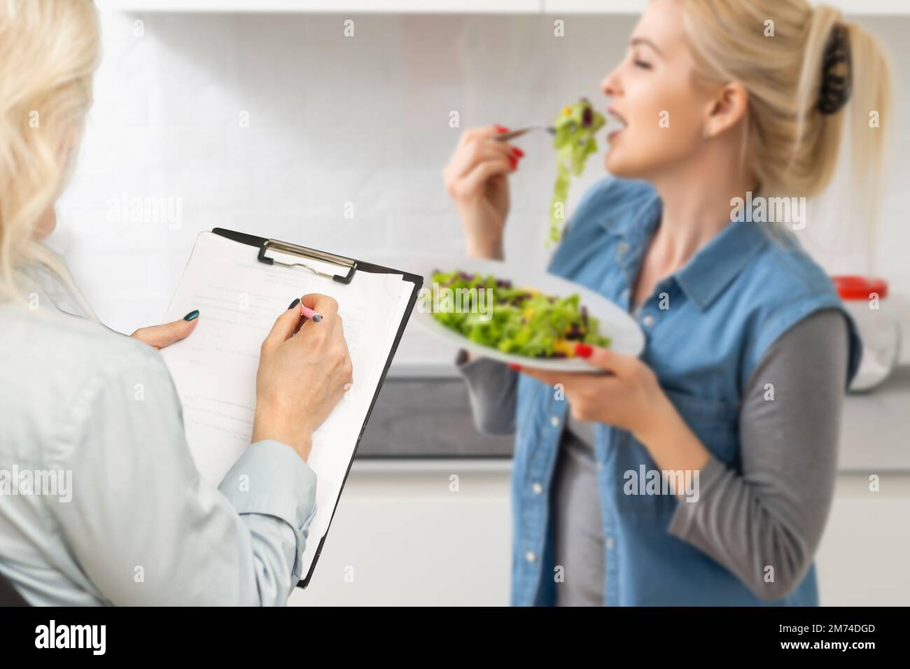 A smiling nutritionist advises a young patient woman on proper ...