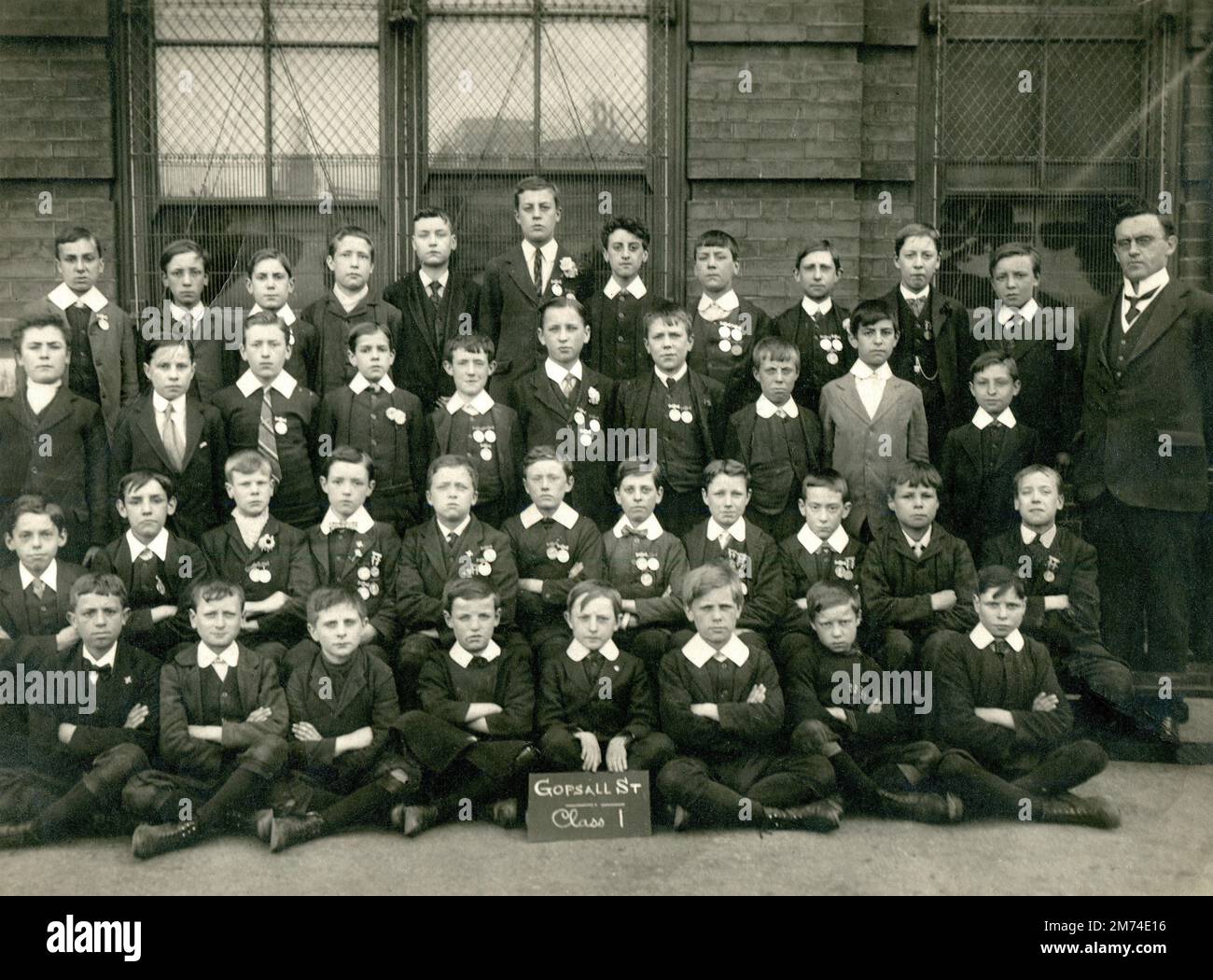 London. circa. 1912. A class of young schoolboys and their teacher pose ...