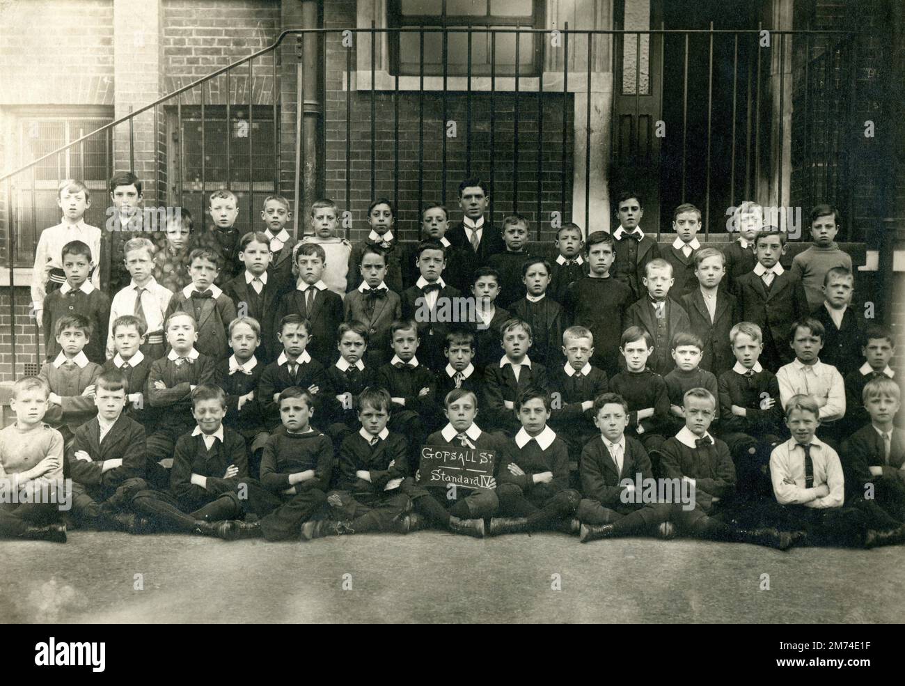 London. circa. 1910. A class of young schoolboys and their teacher pose ...
