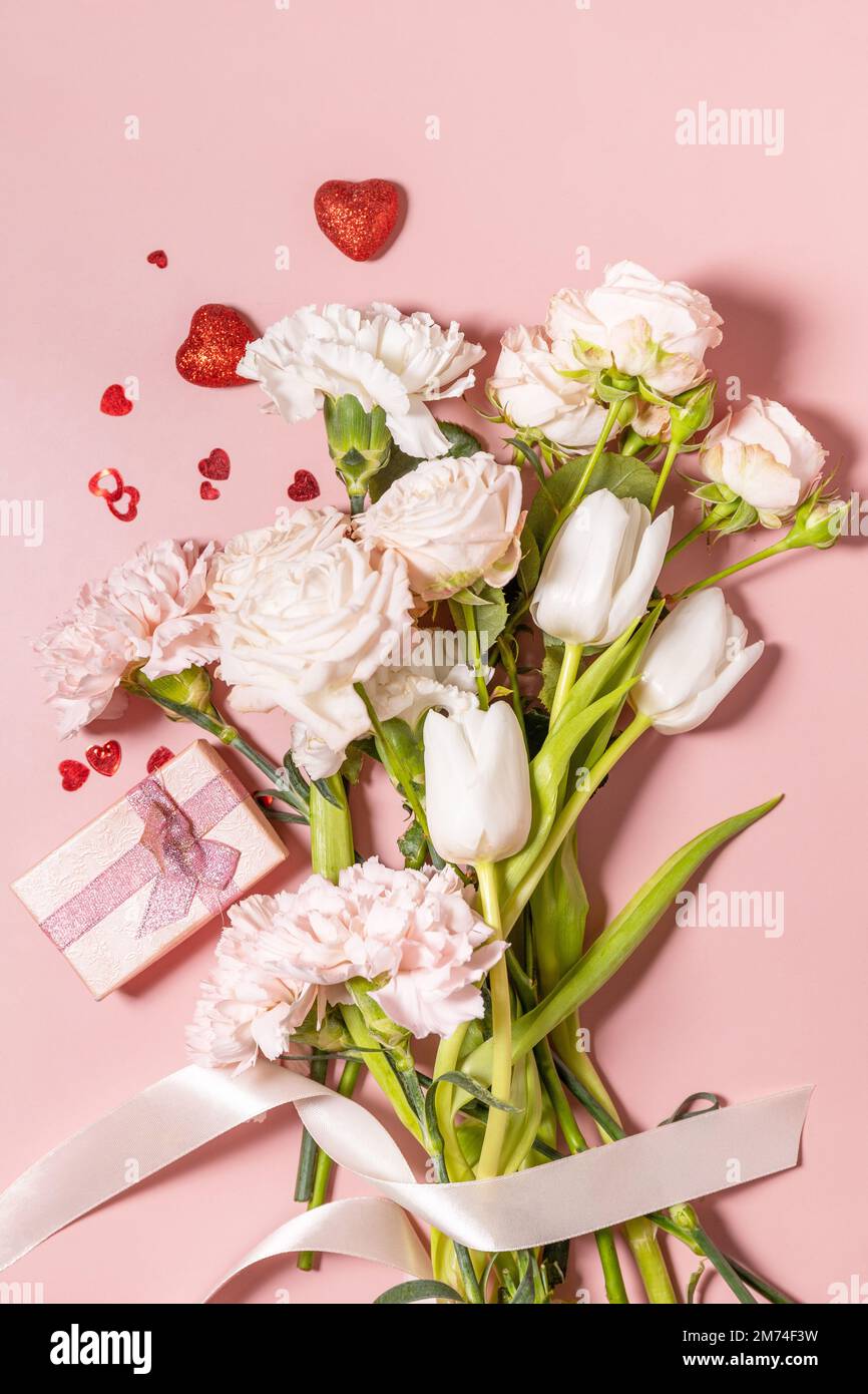 Valentine's Day greeting card with beautiful flowers and gift on pink ...