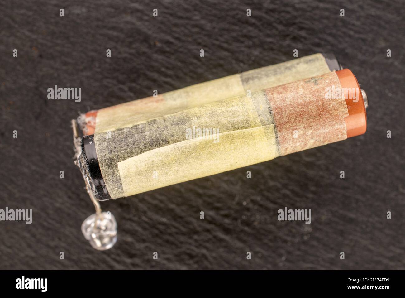 A flashlight with two batteries and a diode on a shale stone, top view ...