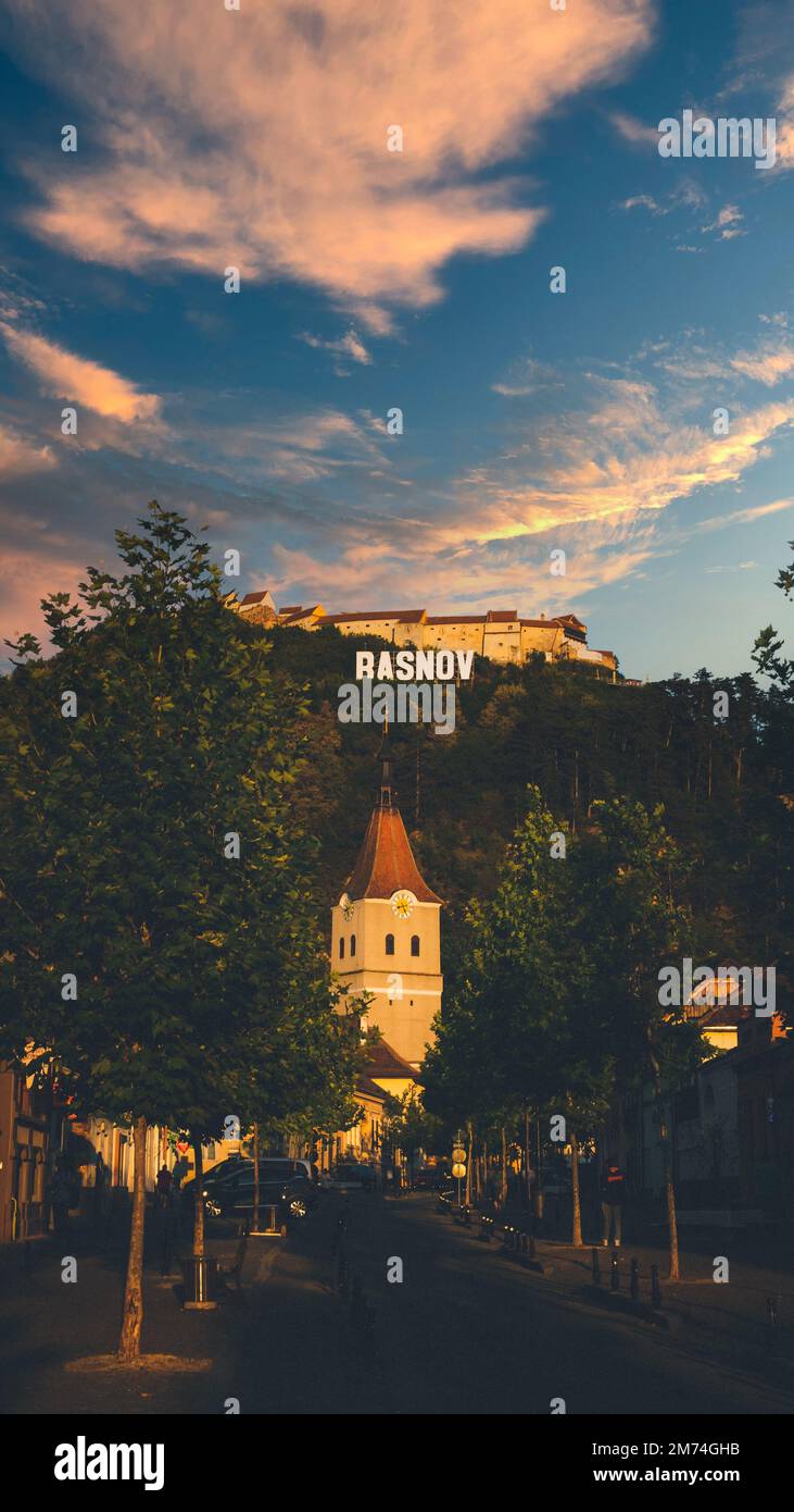 A vertical shot of a sunset sky over a cliff with historic buildings in ...