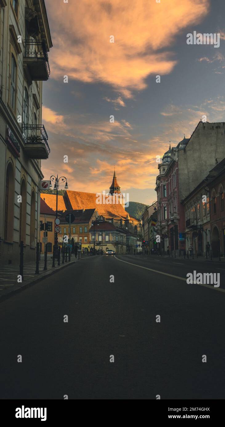 A vertical shot of a sunset sky over an alley with historic buildings ...