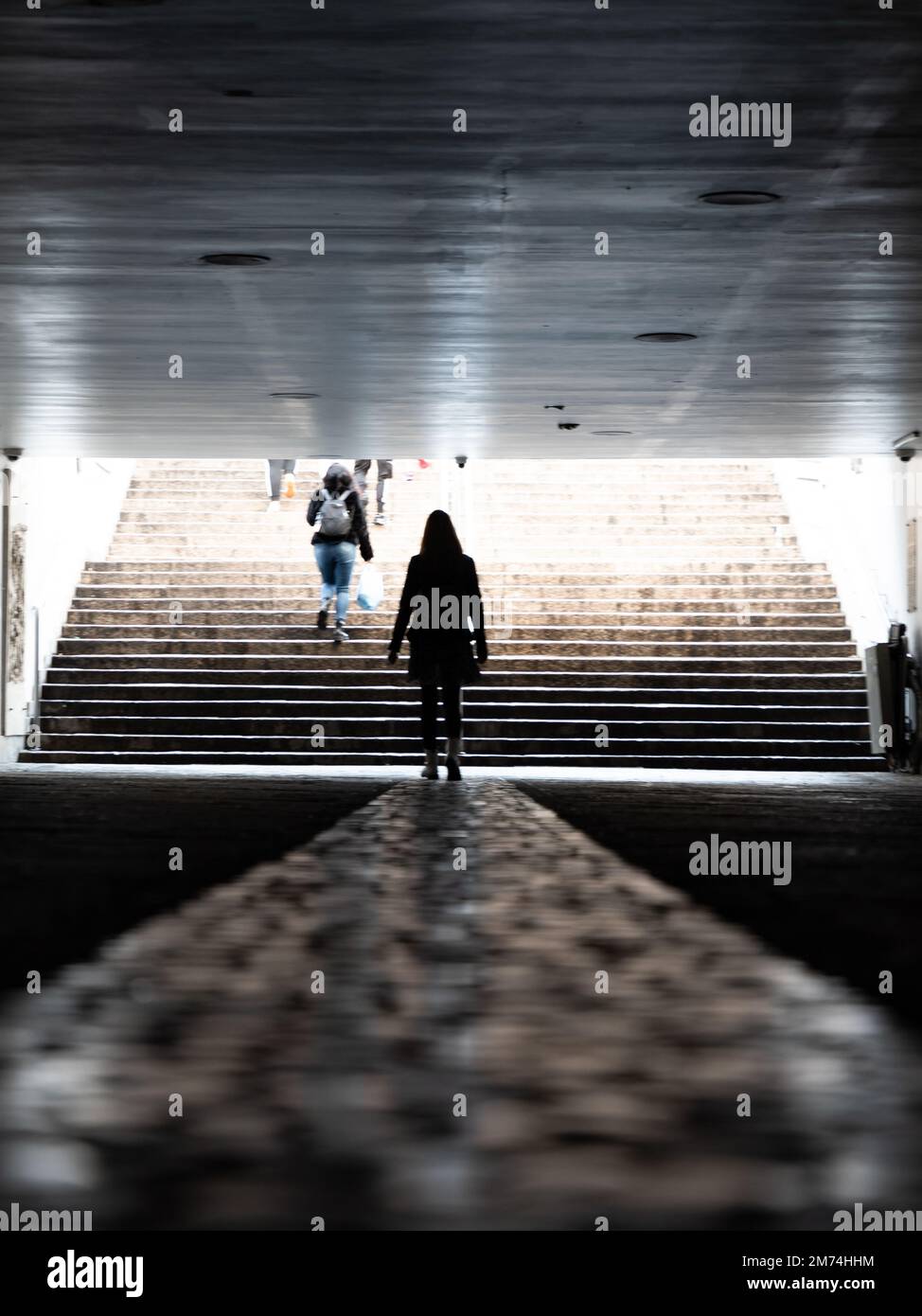 A vertical shot of people climbing up stairs at a subway station in ...