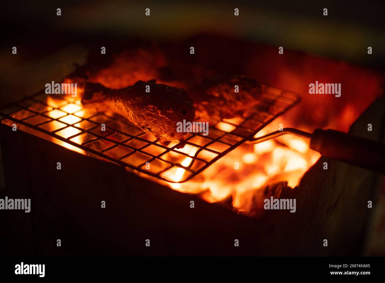 Meat and chicken with veg being roasted over a barbeque wood and coal ...