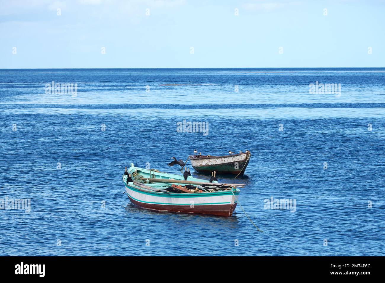An aerial beautiful view of boats sailing on bright blue water under a ...