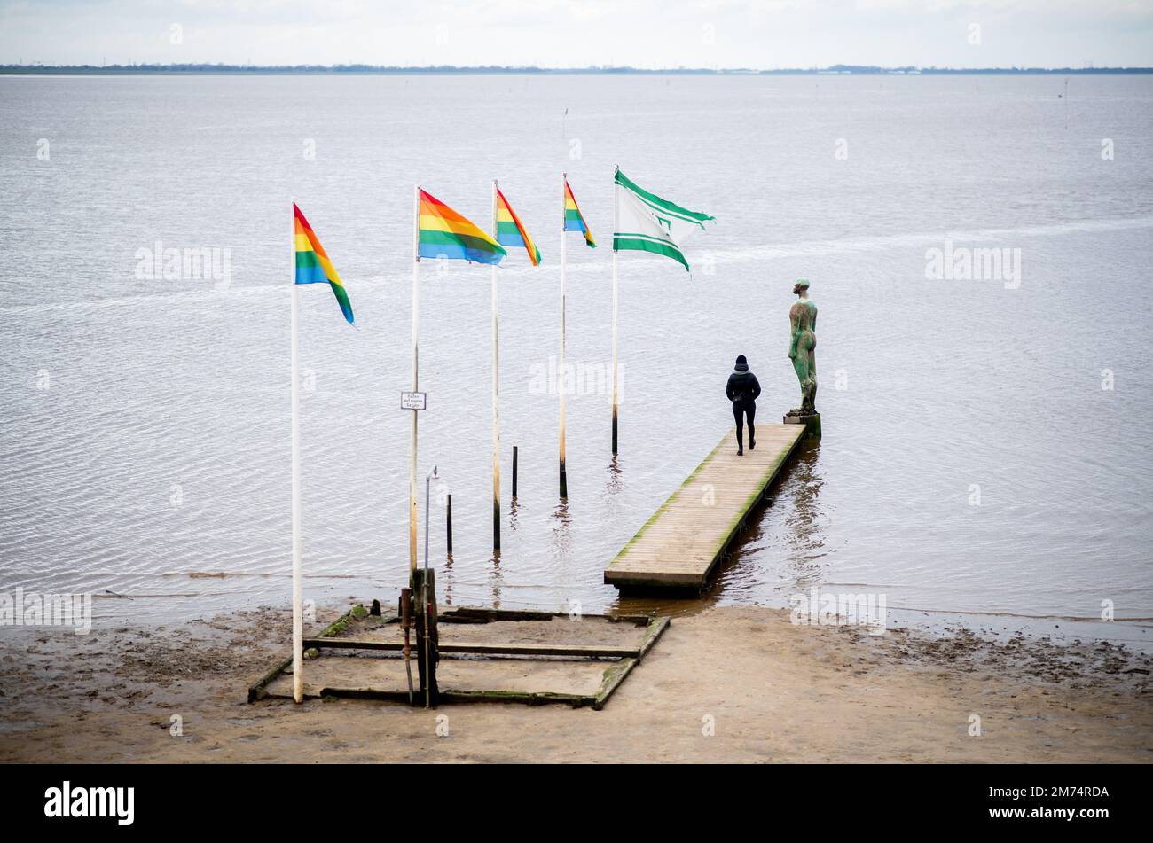 Dangast, Germany. 07th Jan, 2023. A young woman walks in gloomy weather ...