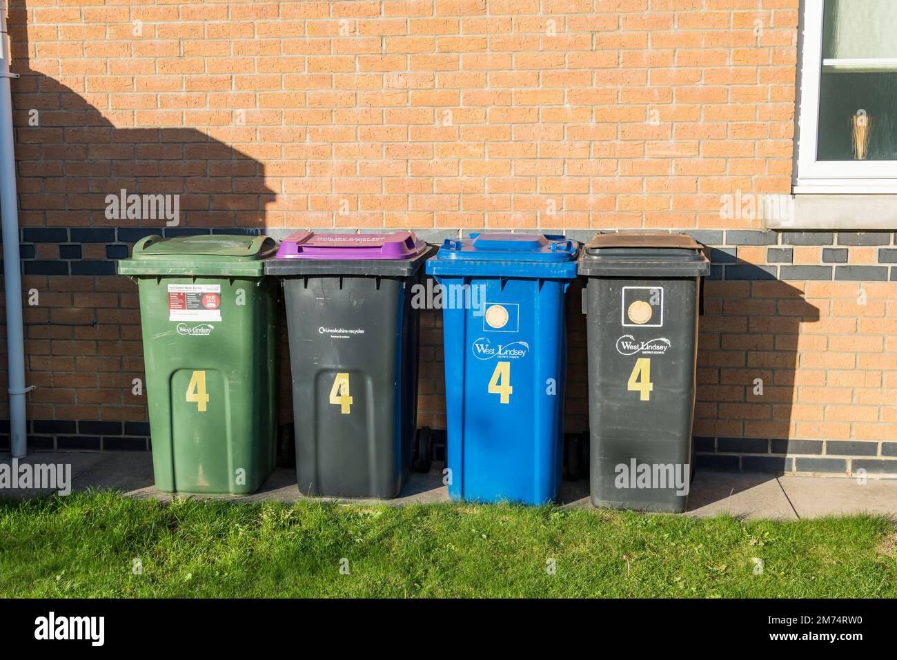 Rubbish bins lined up at side of house Stock Photo - Alamy