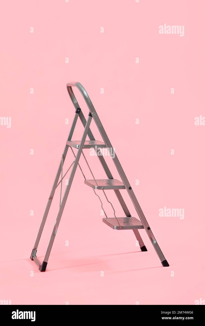 Maintenance ladder on pink background Stock Photo - Alamy