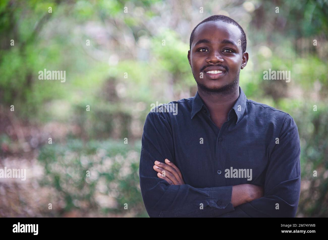 African man stand with his hands crossed and gave a friendly smile.The ...