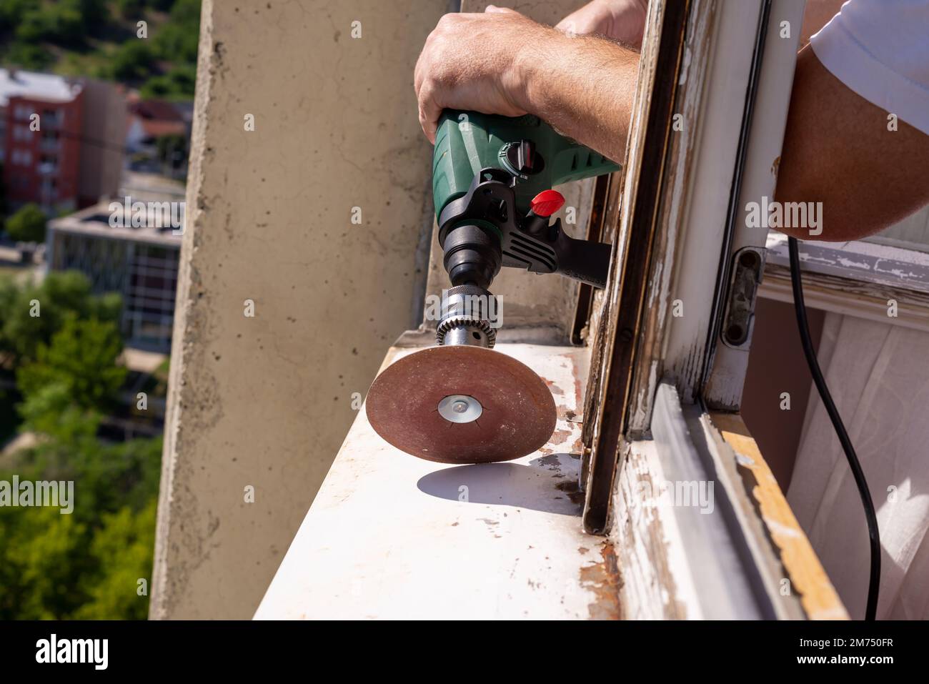 Renovation of an old window sill - a machine during sanding rust from ...