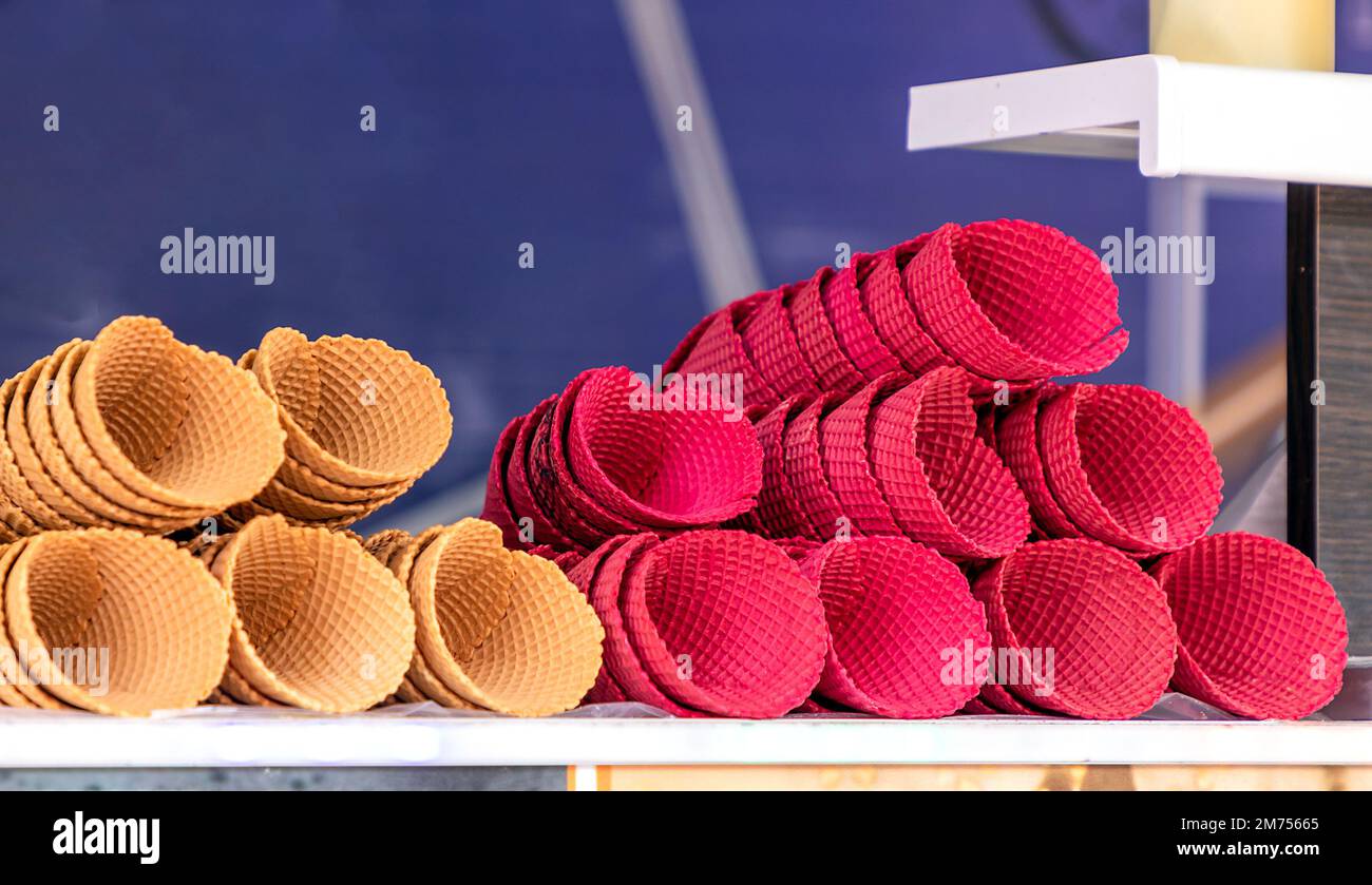 Stack of colorful biscuit waffle cones on ice cream stand on local fair ...