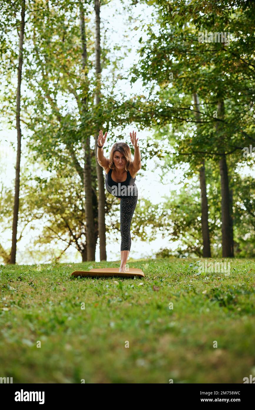 A fit yogi woman practices yoga in the forest Stock Photo - Alamy