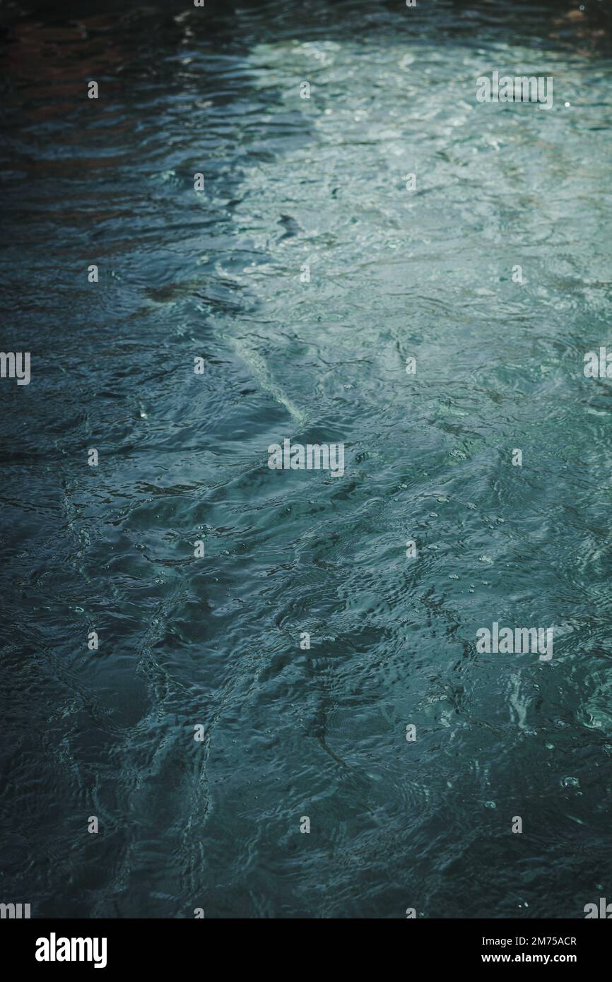 Close up of teal blue swimming pool water. Portrait orientation image ...