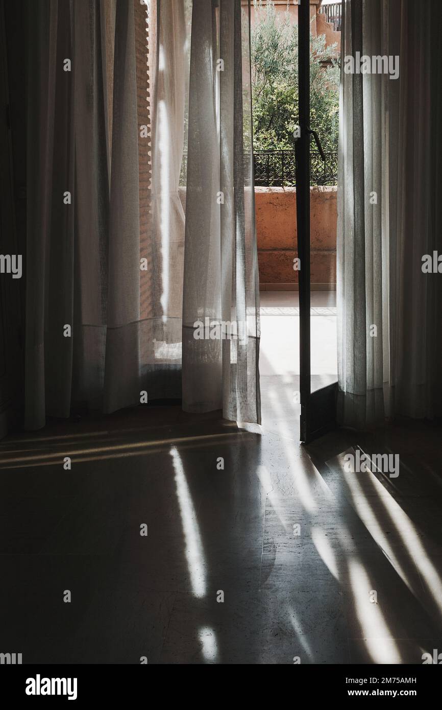 Room interior showing glass french doors leading onto balcony. Curtains ...